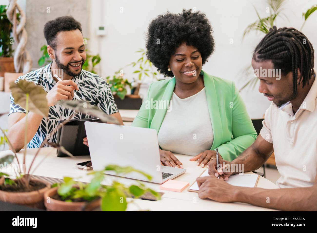 A dynamic team of three professionals engages in a collaborative work ...