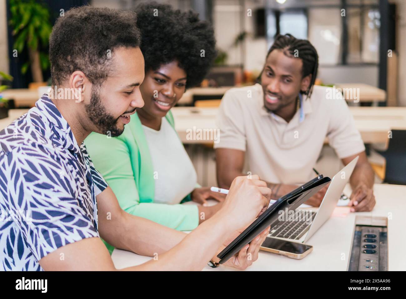 Three professionals engaged in a collaborative work session in a modern ...