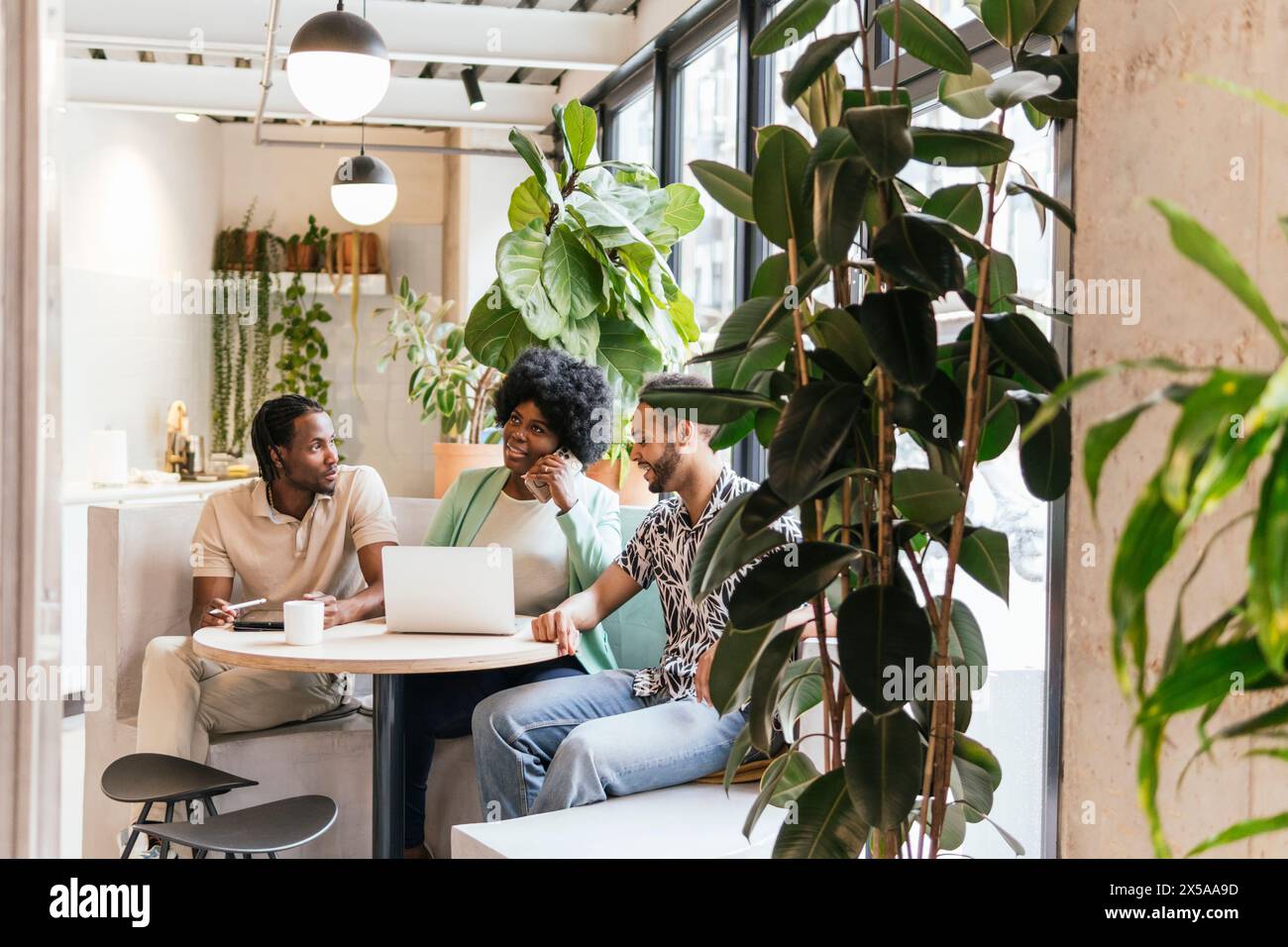 Three young entrepreneurs engage in a collaborative discussion in a ...