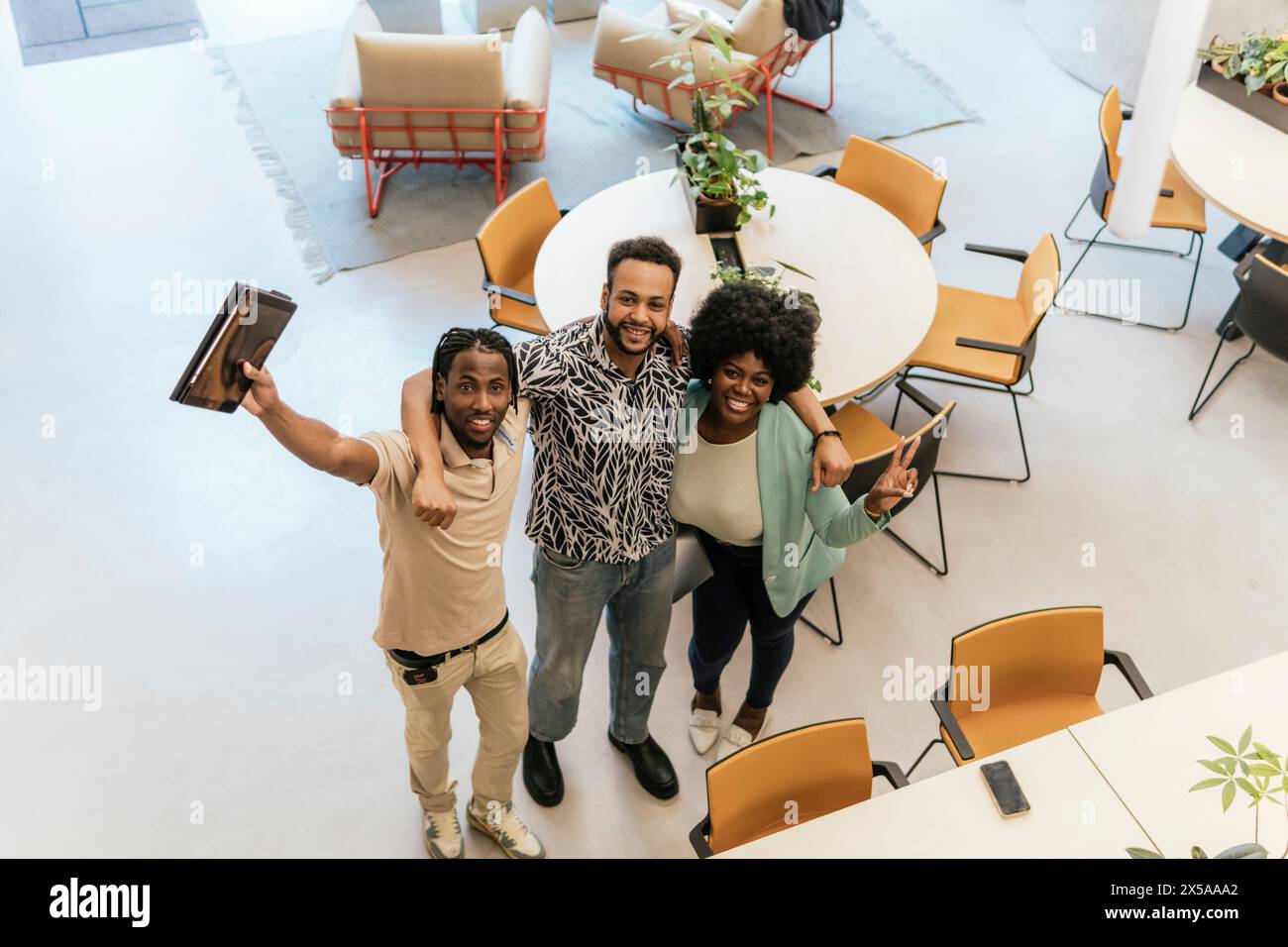 A diverse group of professionals takes a joyful selfie during a ...
