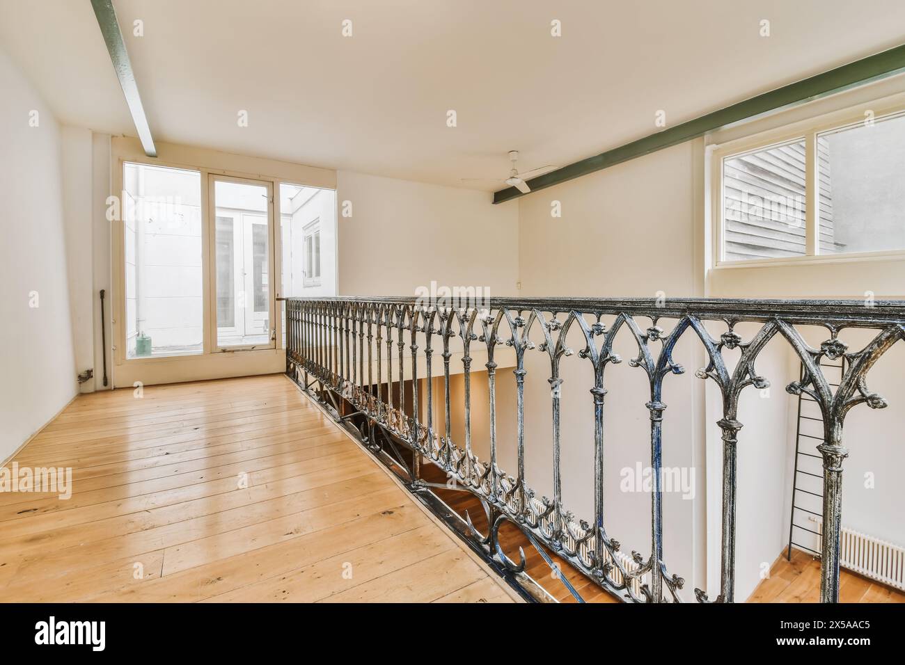 Bright and spacious empty hallway featuring wooden floors and an ornate ...