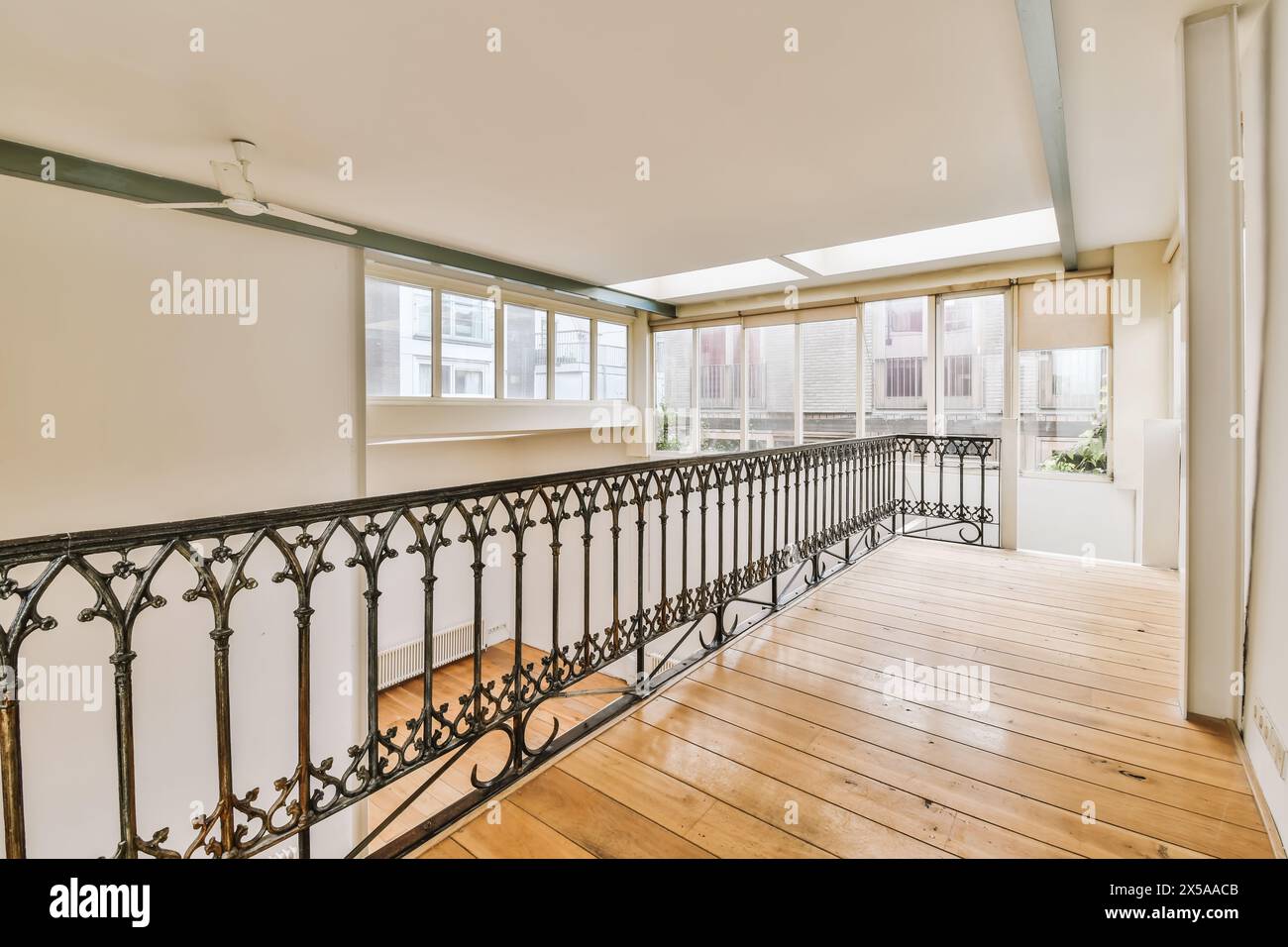 Bright, airy interior space featuring hardwood floors, ornate balcony ...