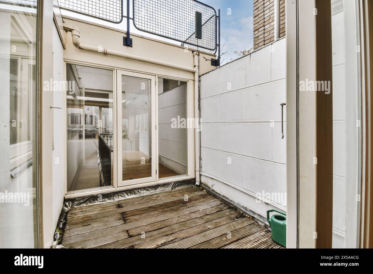 An enclosed residential balcony area with glass sliding doors, wooden ...
