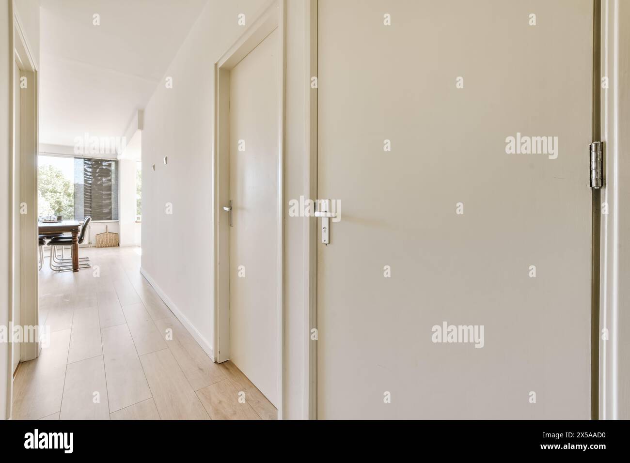 Bright and airy corridor in a modern home, looking into a sunlit room ...