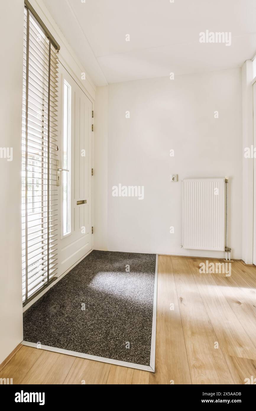 A bright, empty entryway featuring white walls, wooden floor, a ...