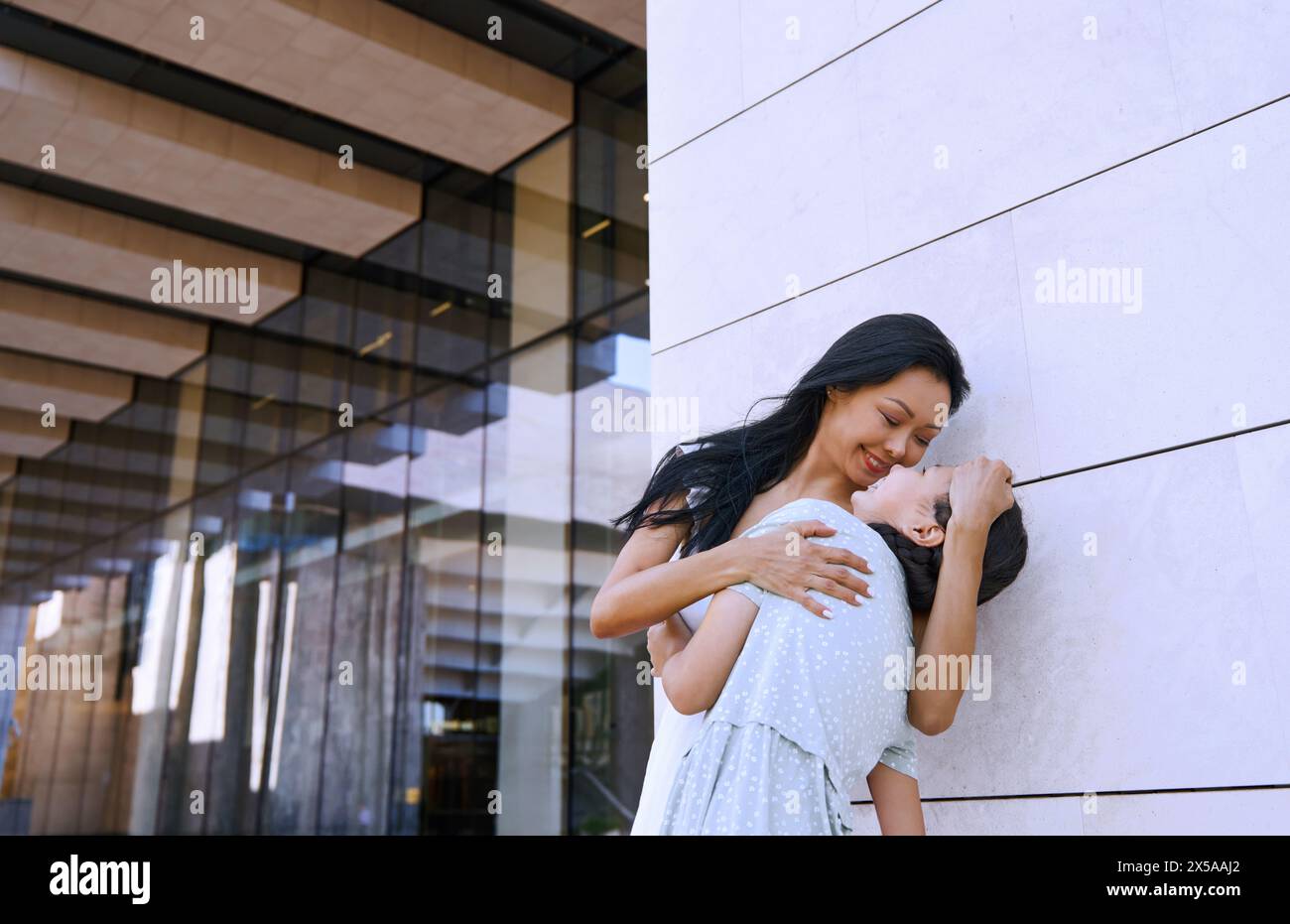 Girl with autism spectrum hugging her mother while walking in the city ...