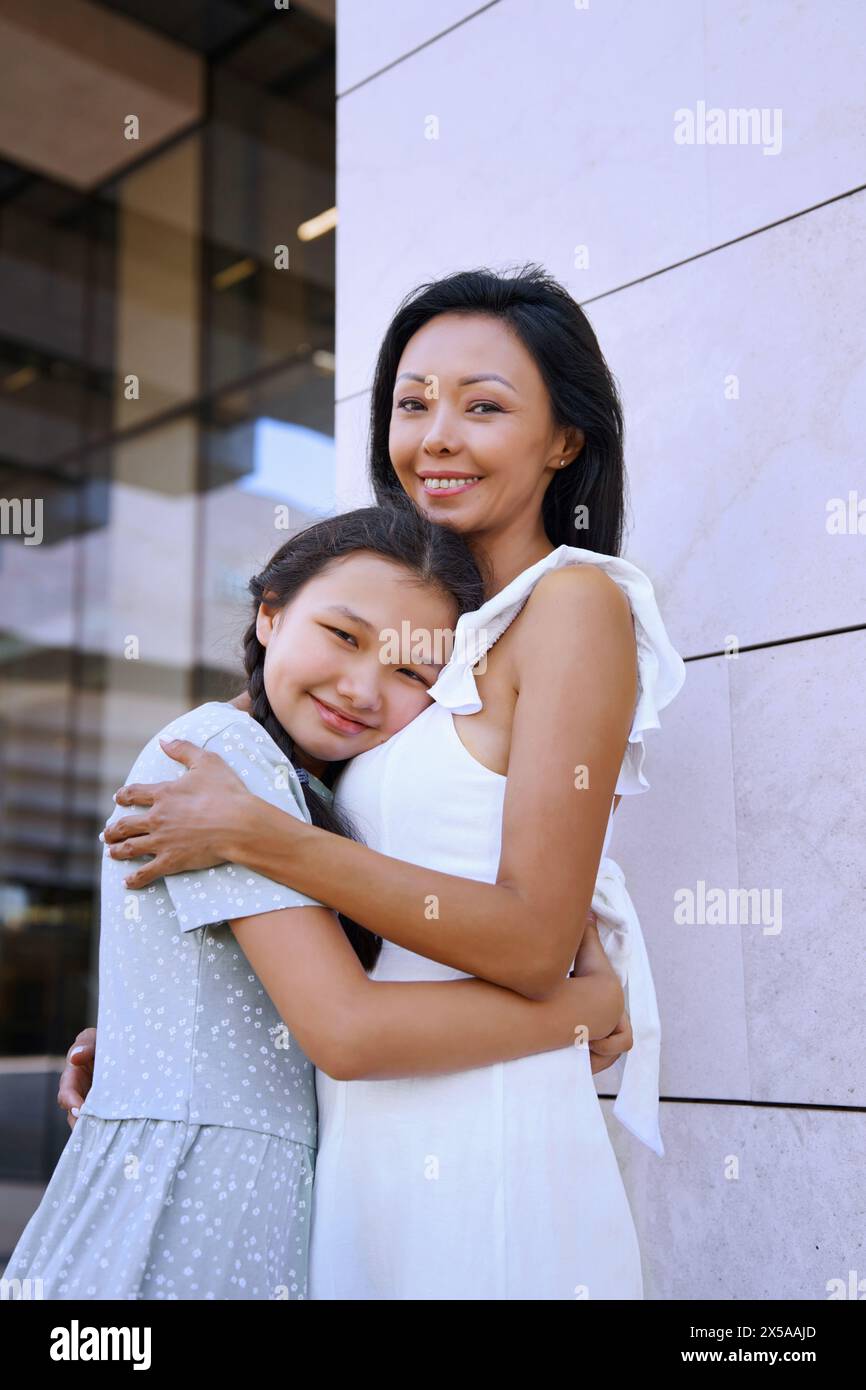 Girl with autism spectrum having fun and hugging her mother while ...