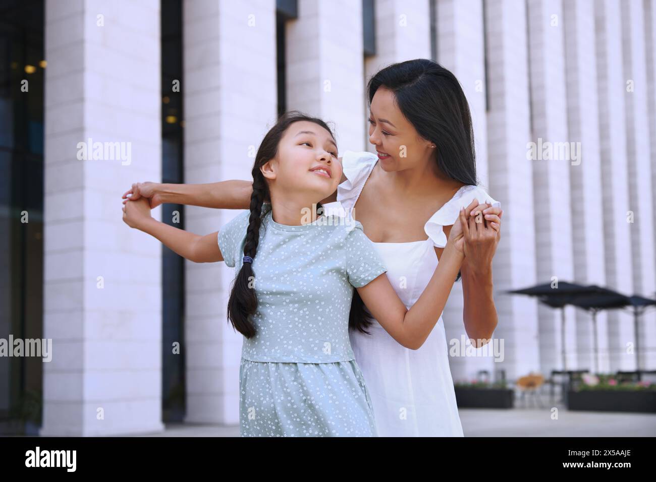 Girl with autism spectrum dancing with her mother while walking in the ...