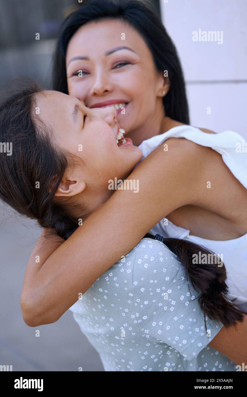 Girl with autism spectrum having fun and hugging her mother while ...
