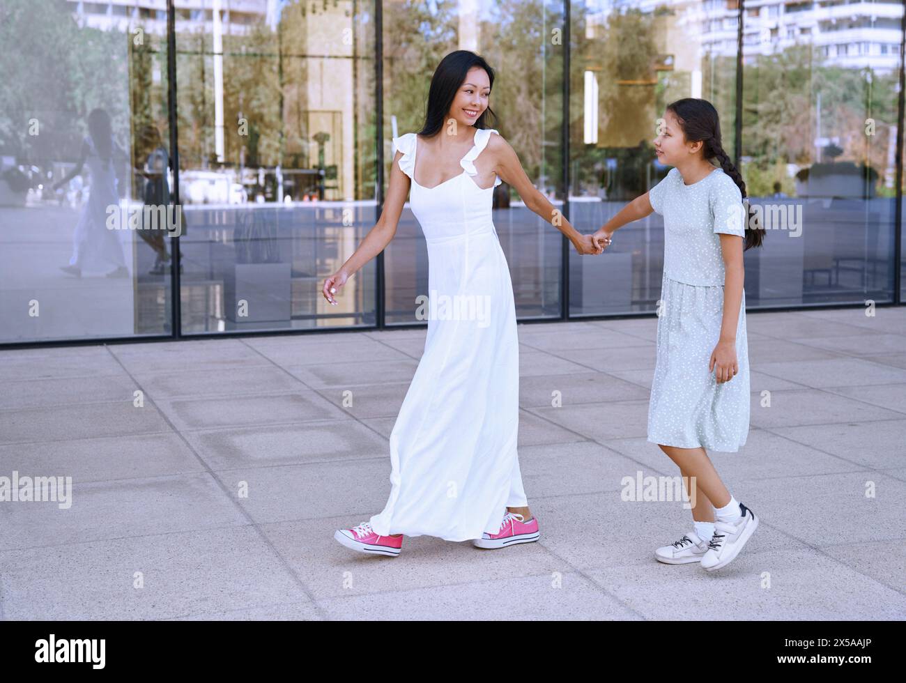 Woman and her daughter with autism spectrum walking together in the ...