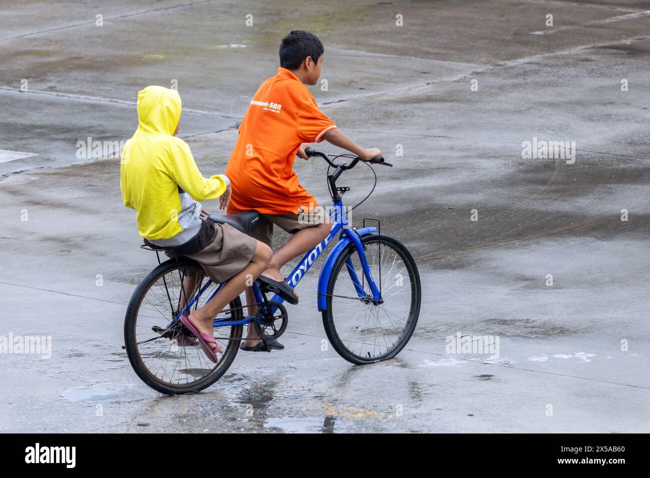 SAMUT PRAKAN, THAILAND, MAR 20 2024, Two boys ride together on one bike Stock Photo - Alamy