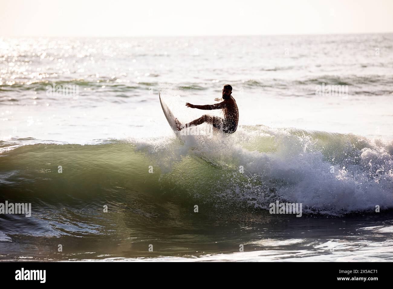 A man, Tourist surfer surfing, cacthing a good wave on spectacular ...