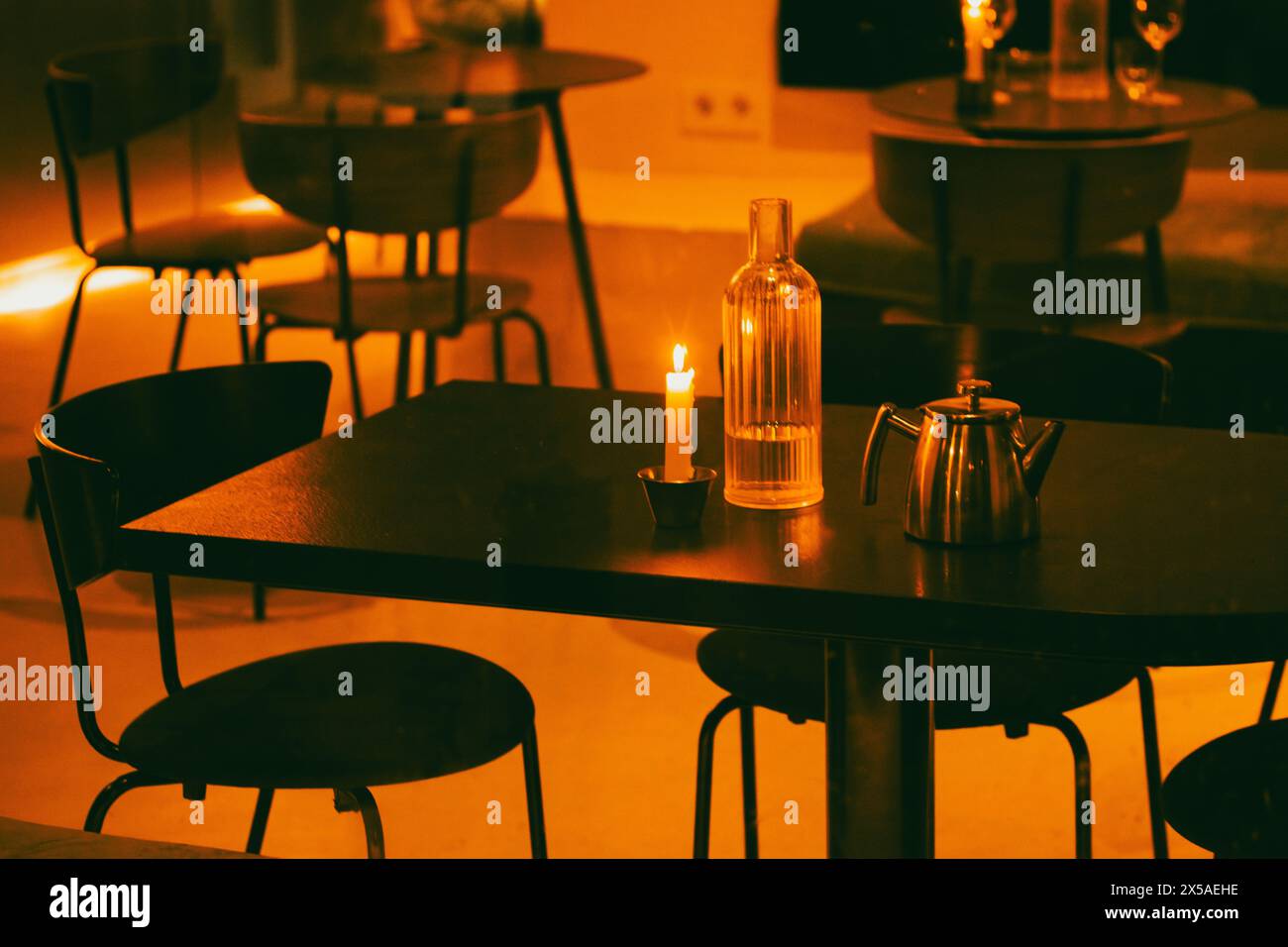 Candlelight dinner in restaurant. Candles in candlesticks burn on black ...