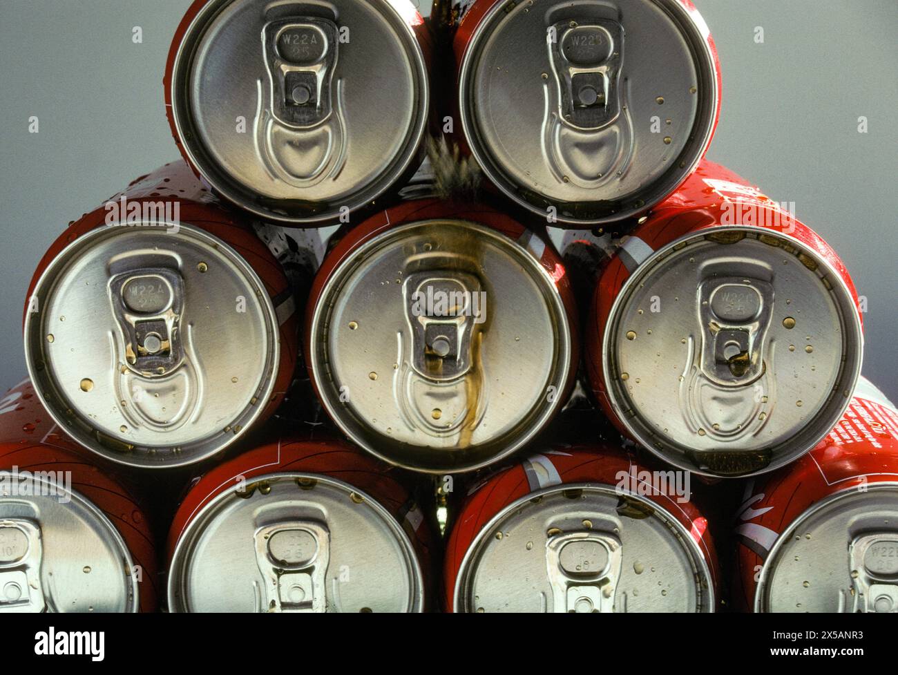 Stack of drinks cans with liquid pouring Stock Photo - Alamy