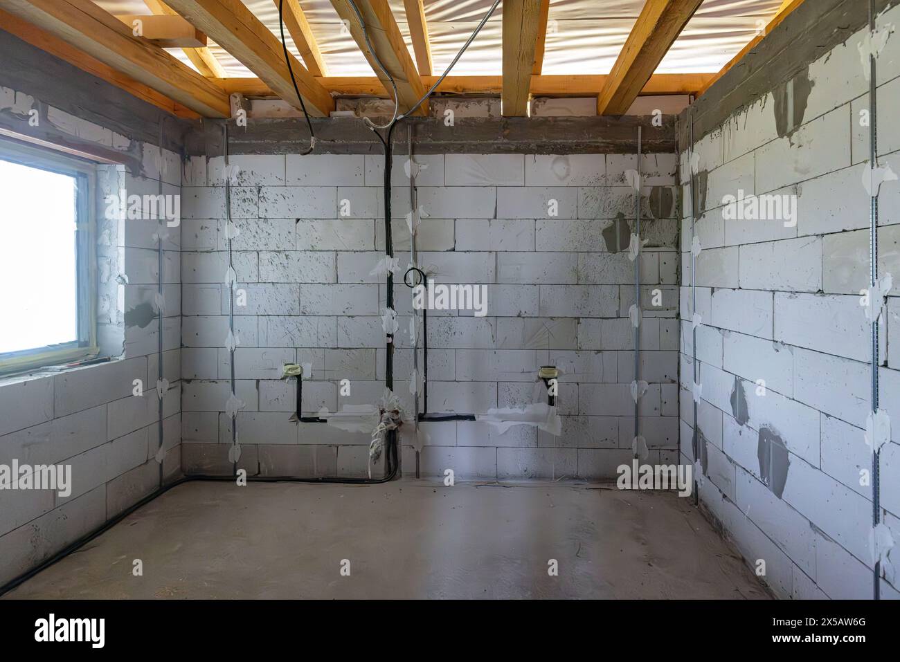 Spacious basement in the midst of construction, with exposed pipes and ...