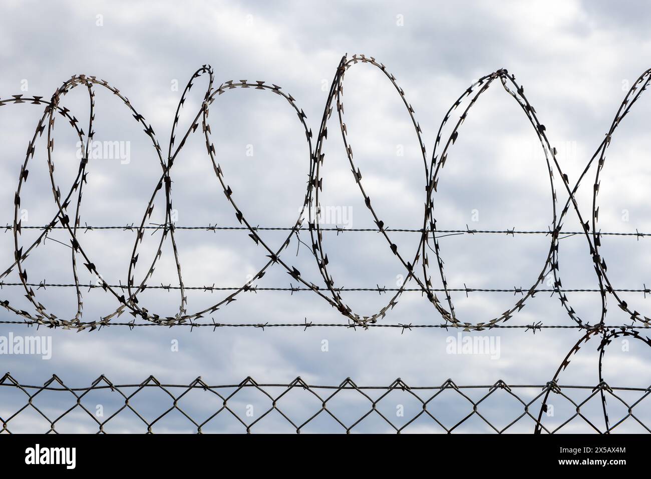 Barbed wire fencing protecting a building Stock Photo - Alamy
