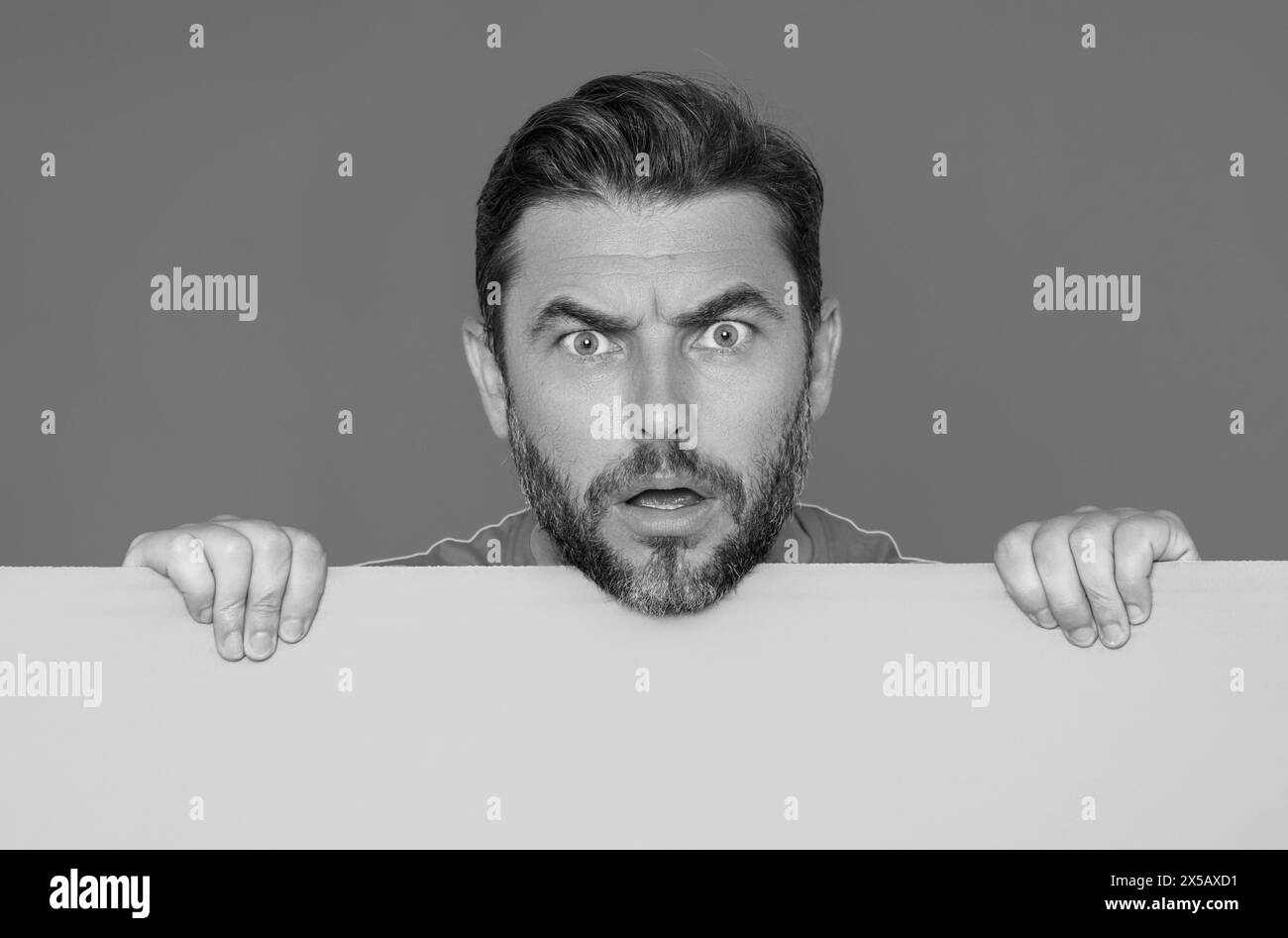 Angry man face with empty board on studio background. Anger guy showing ...