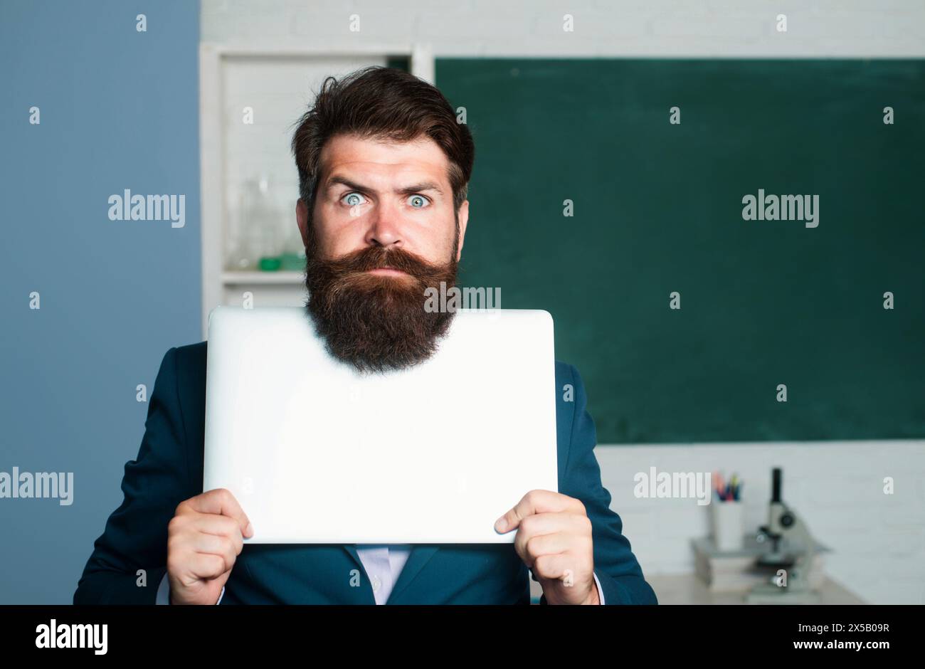 Serious teacher holding laptop, teacher bearded professor with funny ...