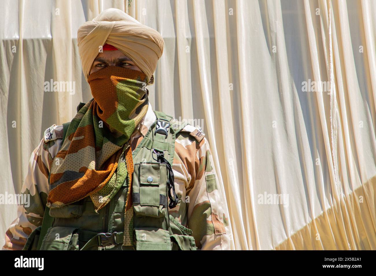 Indian paramilitary trooper stands alert as supporters of the Jammu and ...