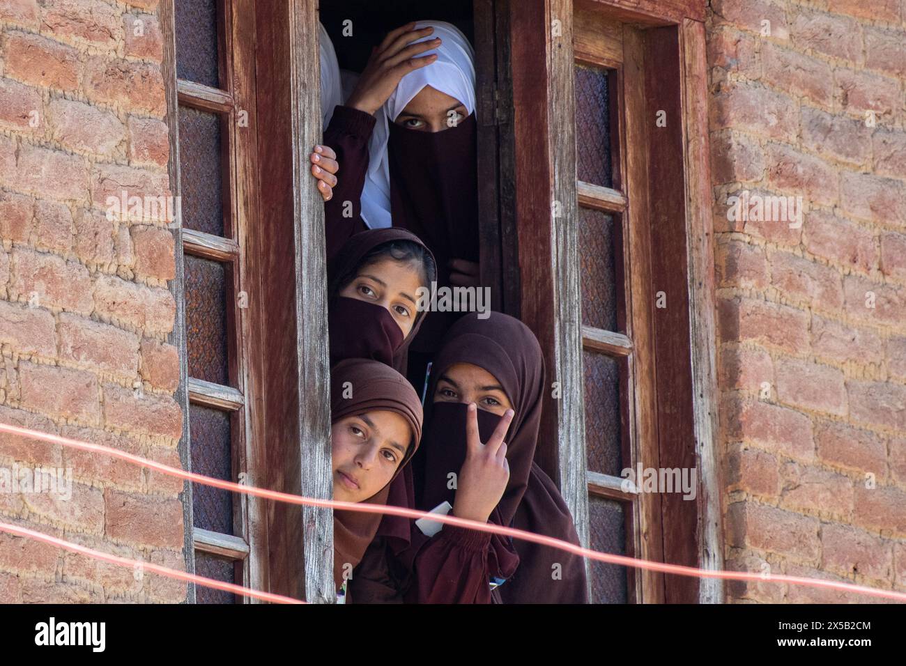 School children look towards the election campaign rally of Jammu and ...