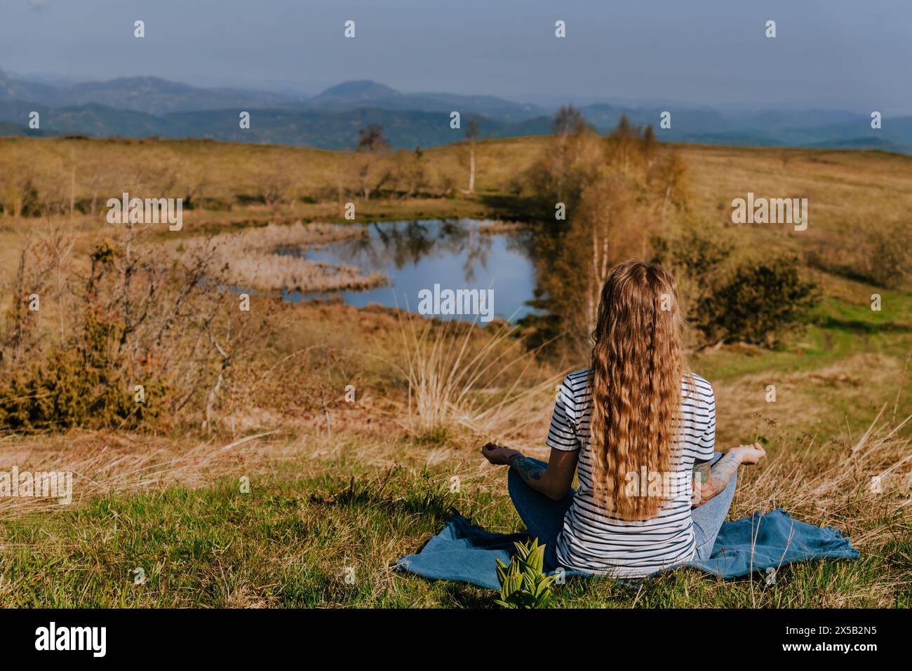 Woman Meditating Sitting Alone near Mountain Lake Stock Photo - Alamy
