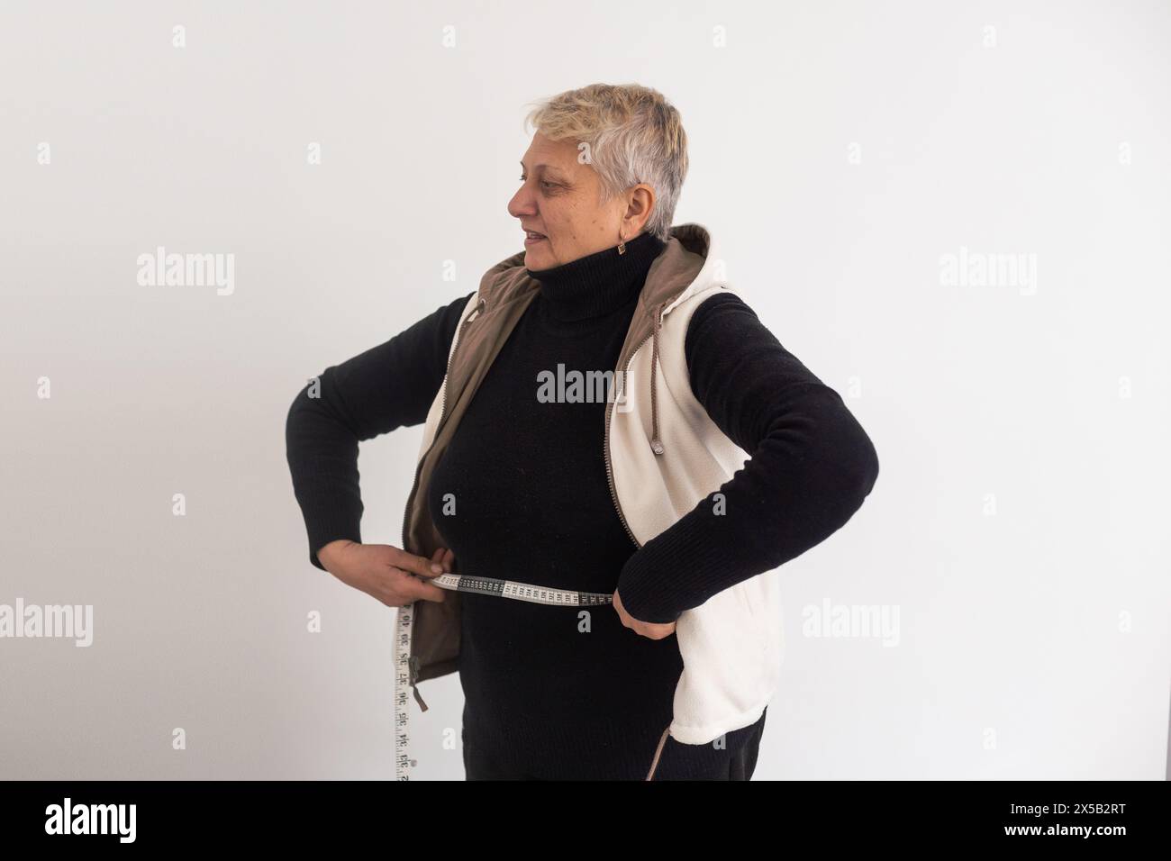 an elderly woman is measured with a tape measure Stock Photo - Alamy