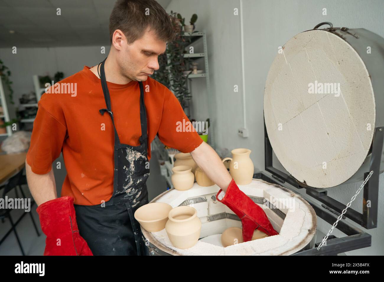 Caucasian man loading ceramic products into a special kiln Stock Photo ...