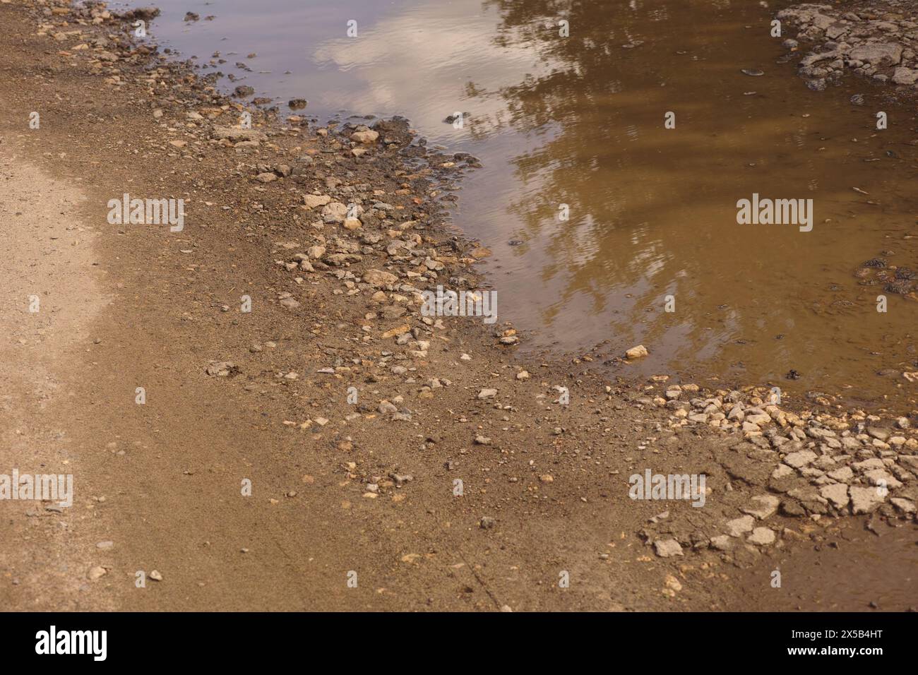 A muddy puddle in a dirt road Stock Photo - Alamy