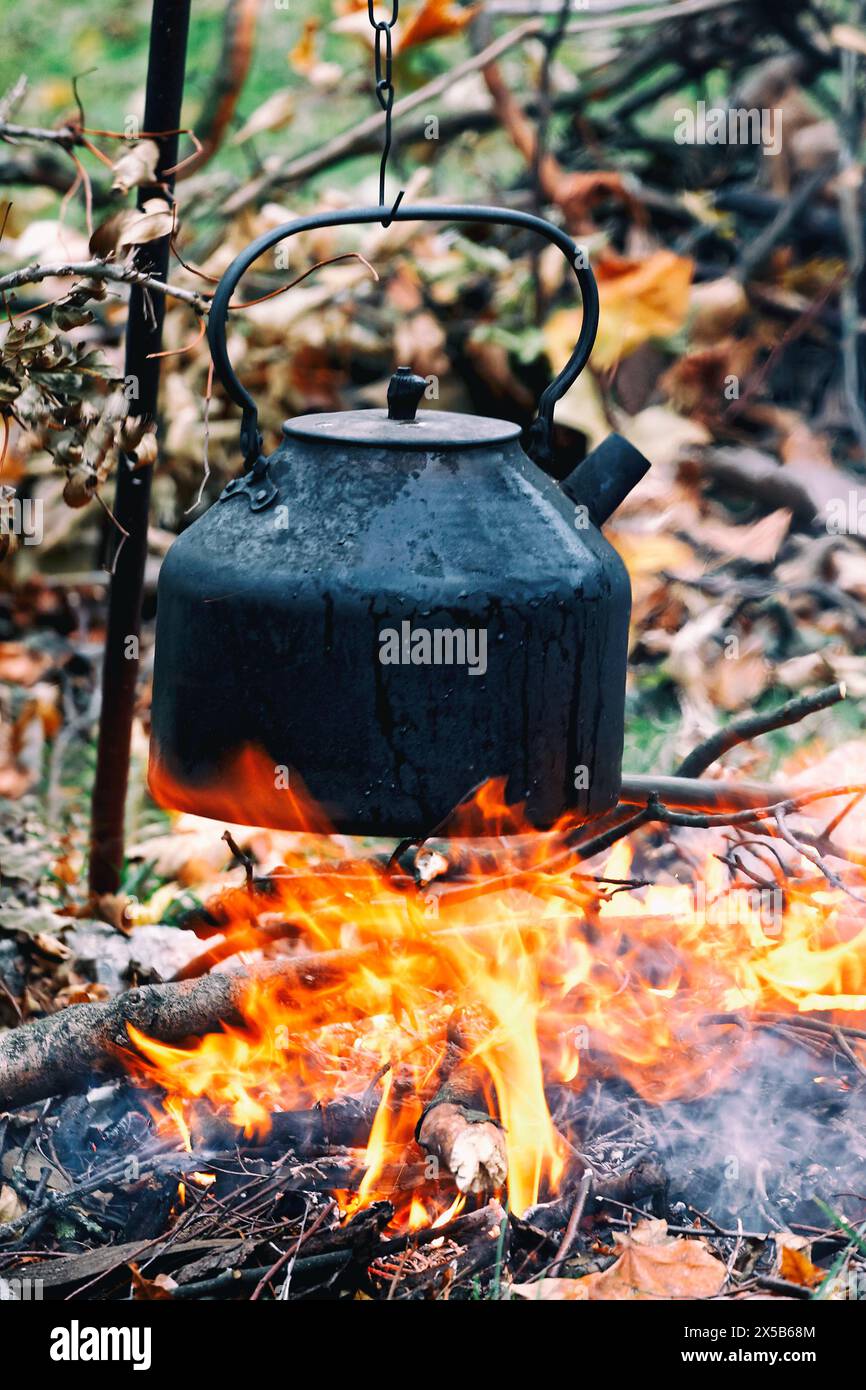 Iron camp kettle water on a fire in forest. Bright flame fire bonfire ...
