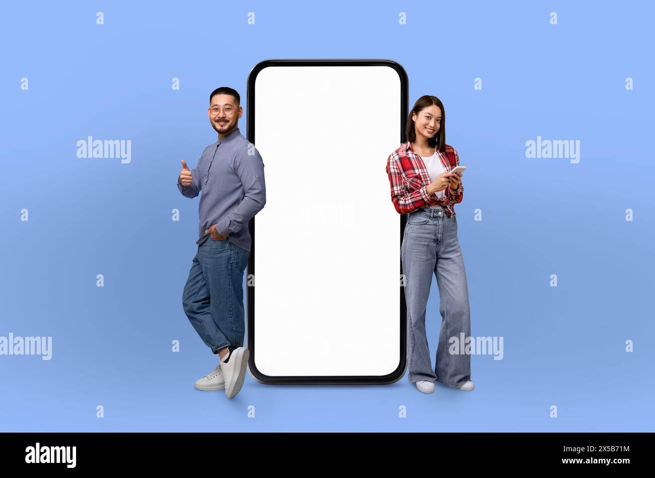 Asian Couple Standing Next to a Big Phone Stock Photo - Alamy