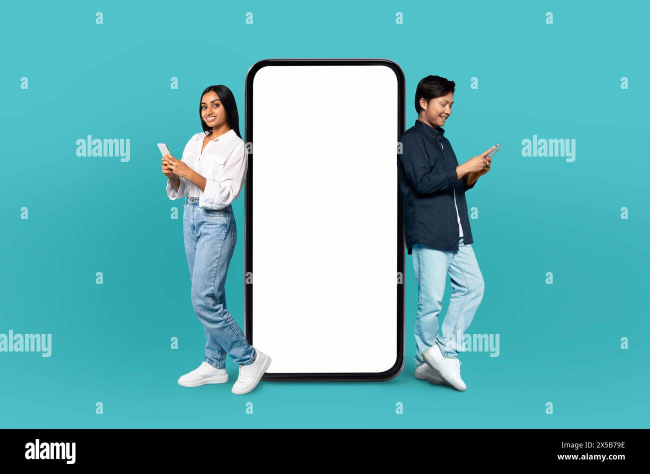 Two People Engaged With Smartphones Standing Beside Large Blank Screen ...