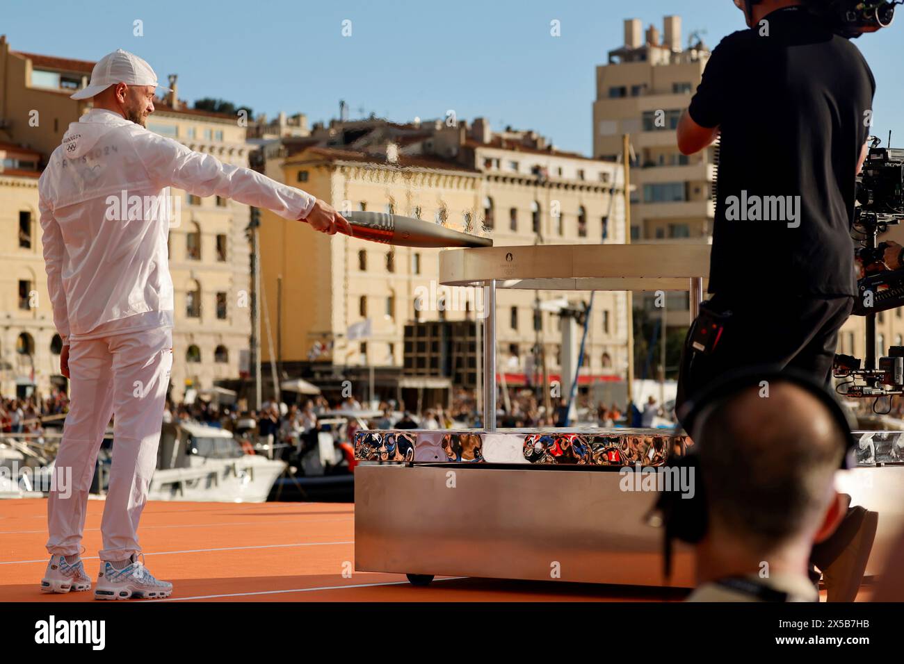 French rapper Jul lights the Olympic cauldron with the Olympic torch in ...