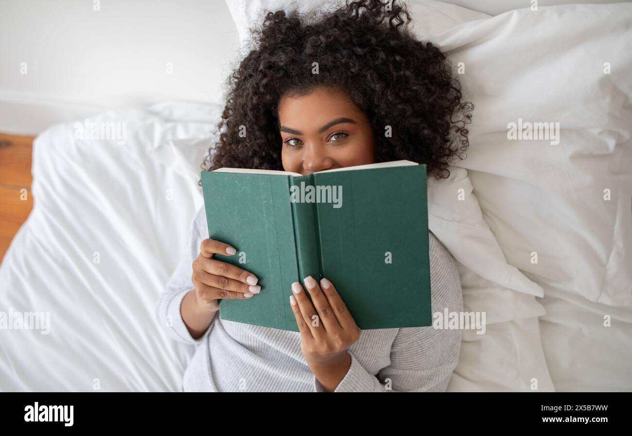 Woman Reading Book While Laying in Bed Stock Photo - Alamy
