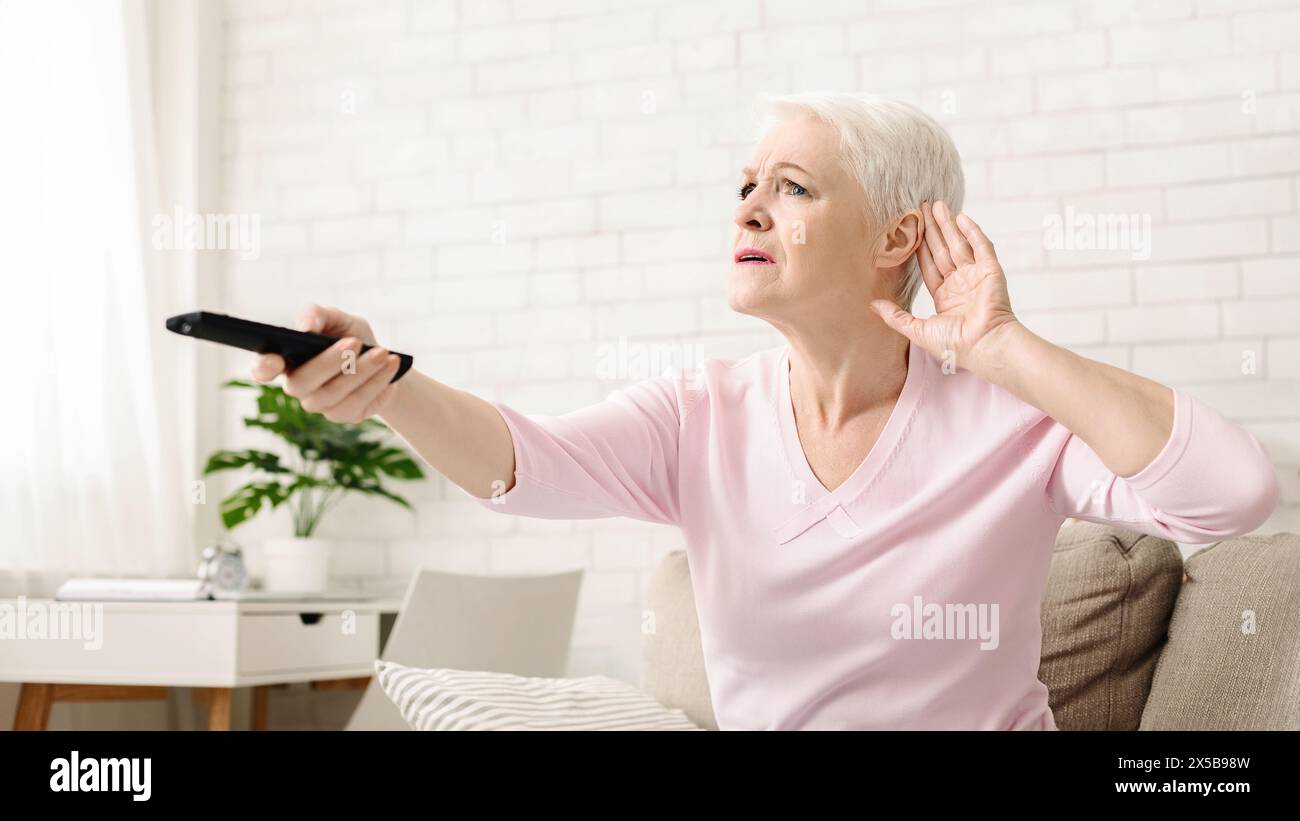 Senior woman cupping her hand behind ear to hear better Stock Photo - Alamy