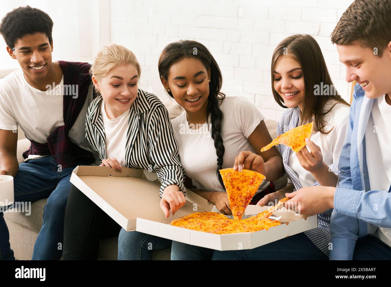 Group of Teenagers Eating Pizza on Couch Stock Photo - Alamy
