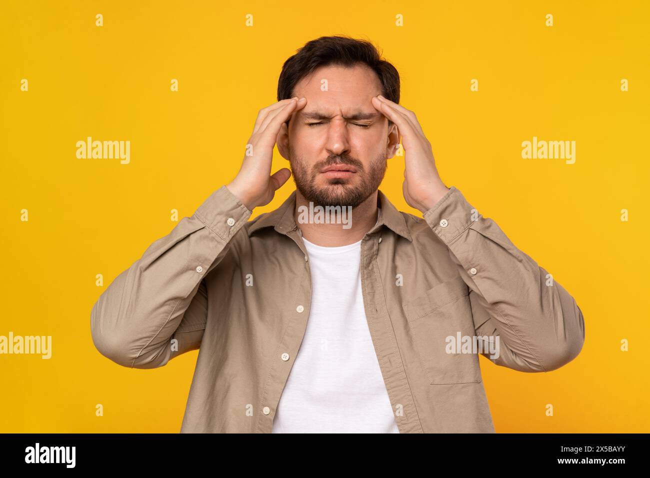 Man With Painful Headache Standing Against a Yellow Background Stock ...