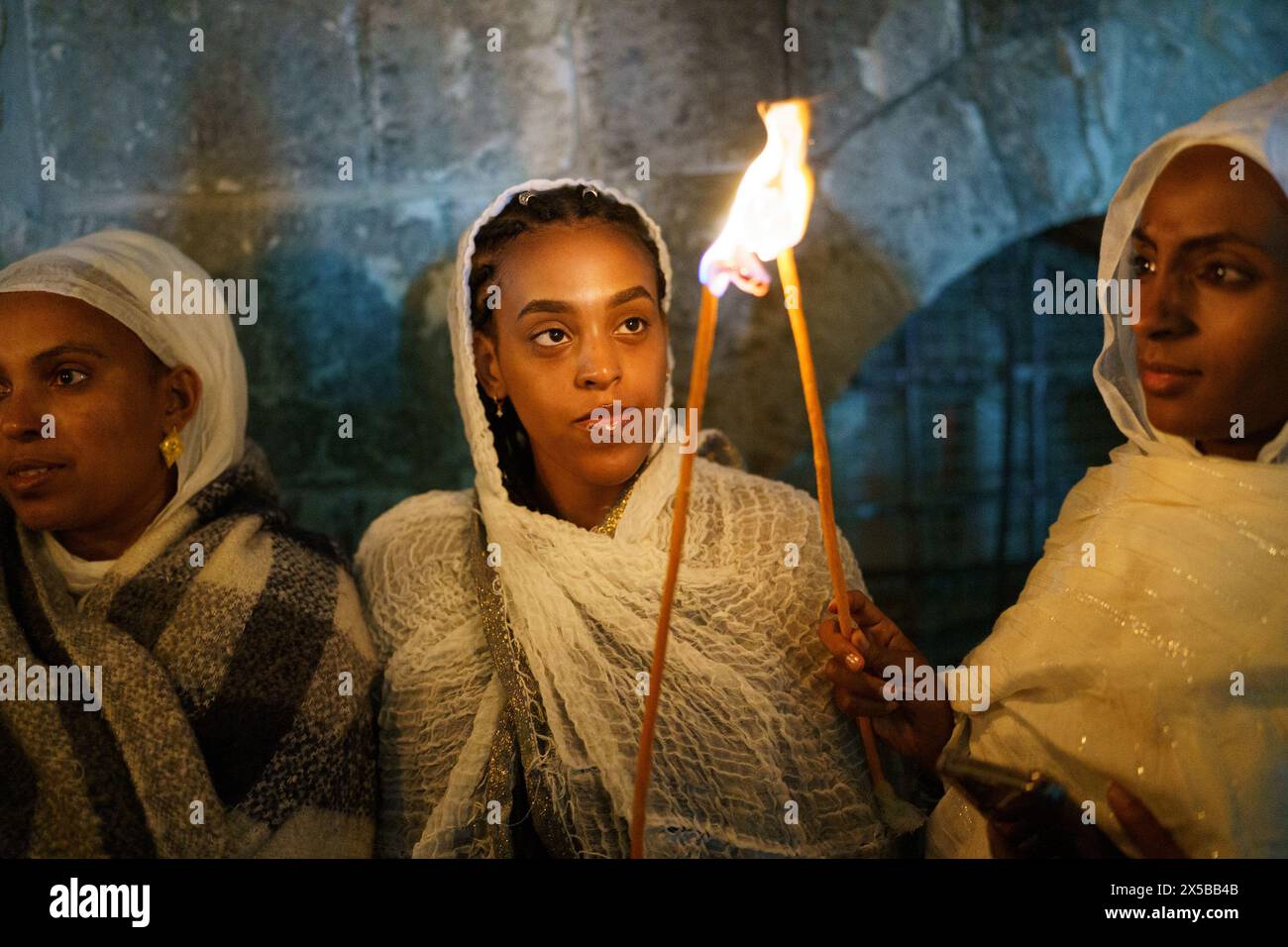 Ethiopian women share the holy fire using candles during the Holy Fire ...