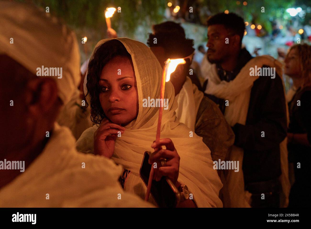 An Ethiopian woman holds a candle during the Holy Fire Ceremony of the ...