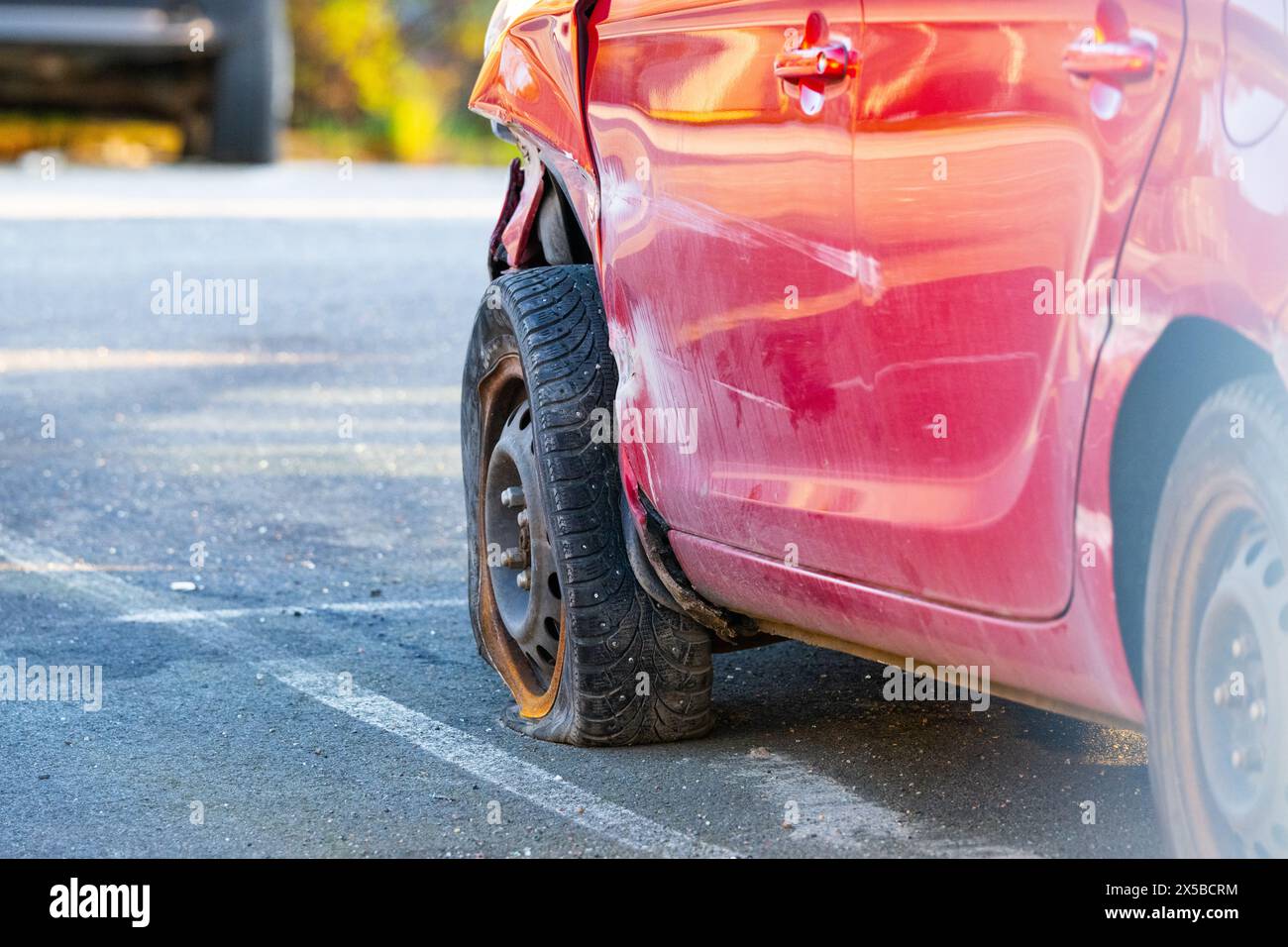 Badly damaged front wheel of a red car Stock Photo - Alamy