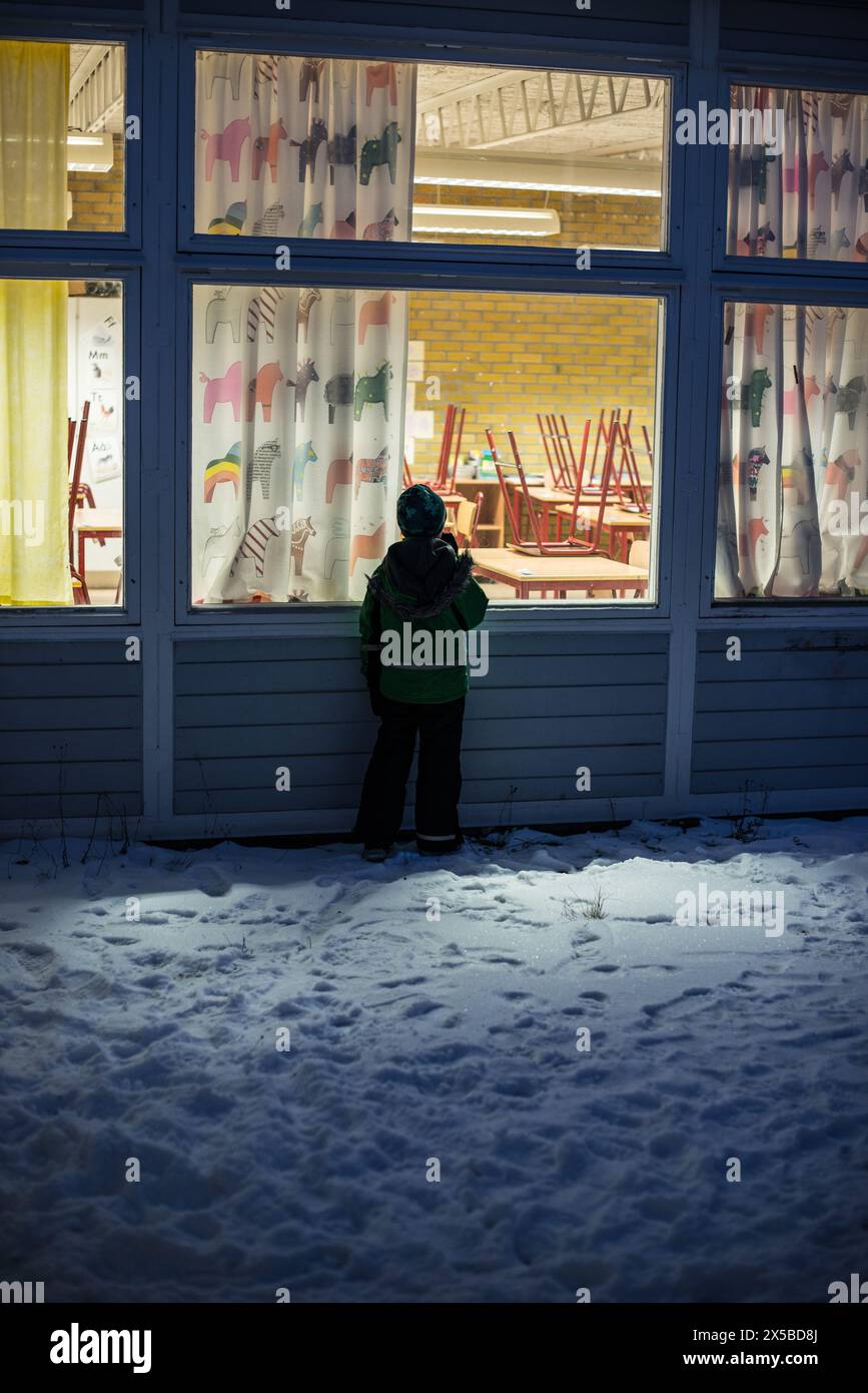 Kid looking into a classroom in the winter Stock Photo - Alamy