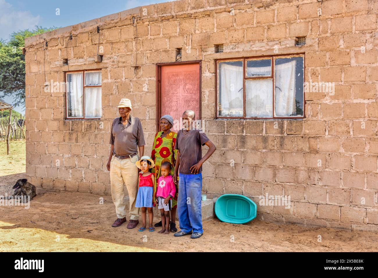 African village, large family standing in front of the house, block ...