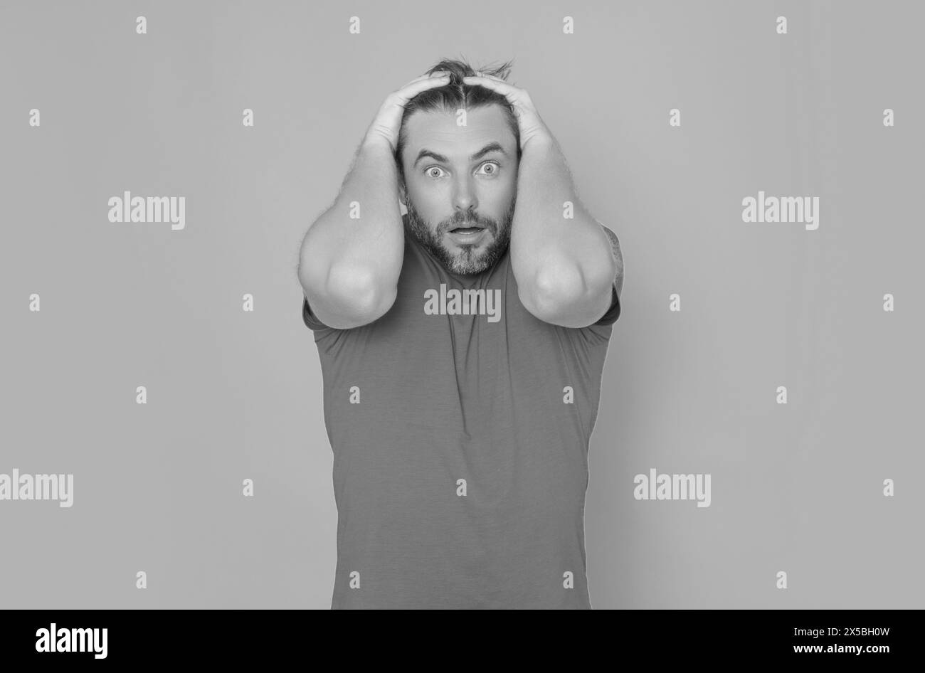 Studio portrait of a man shocked. Surprised man in blue t-shirt ...