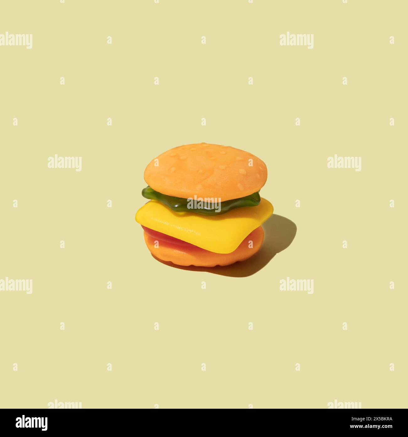 Gummy candy in the shape of a cheeseburger on a light beige background ...
