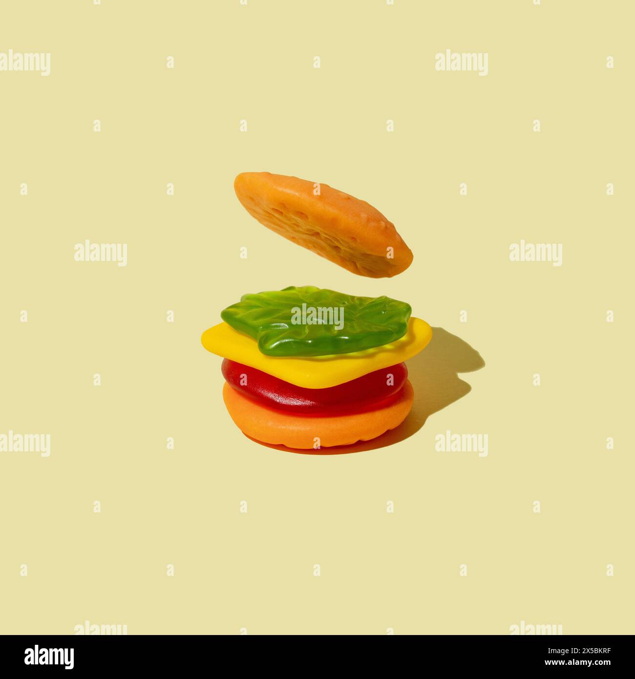 Gummy candy in the shape of a cheeseburger on a light beige background ...