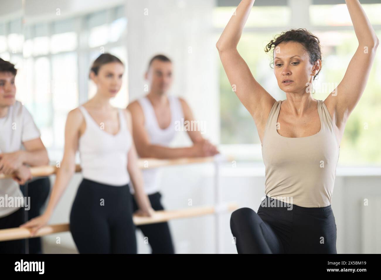 Female ballet teacher showing movements to students in studio Stock ...