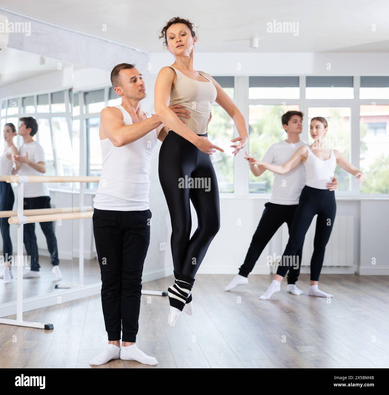 Female ballet dancer performing jump with partner support Stock Photo ...