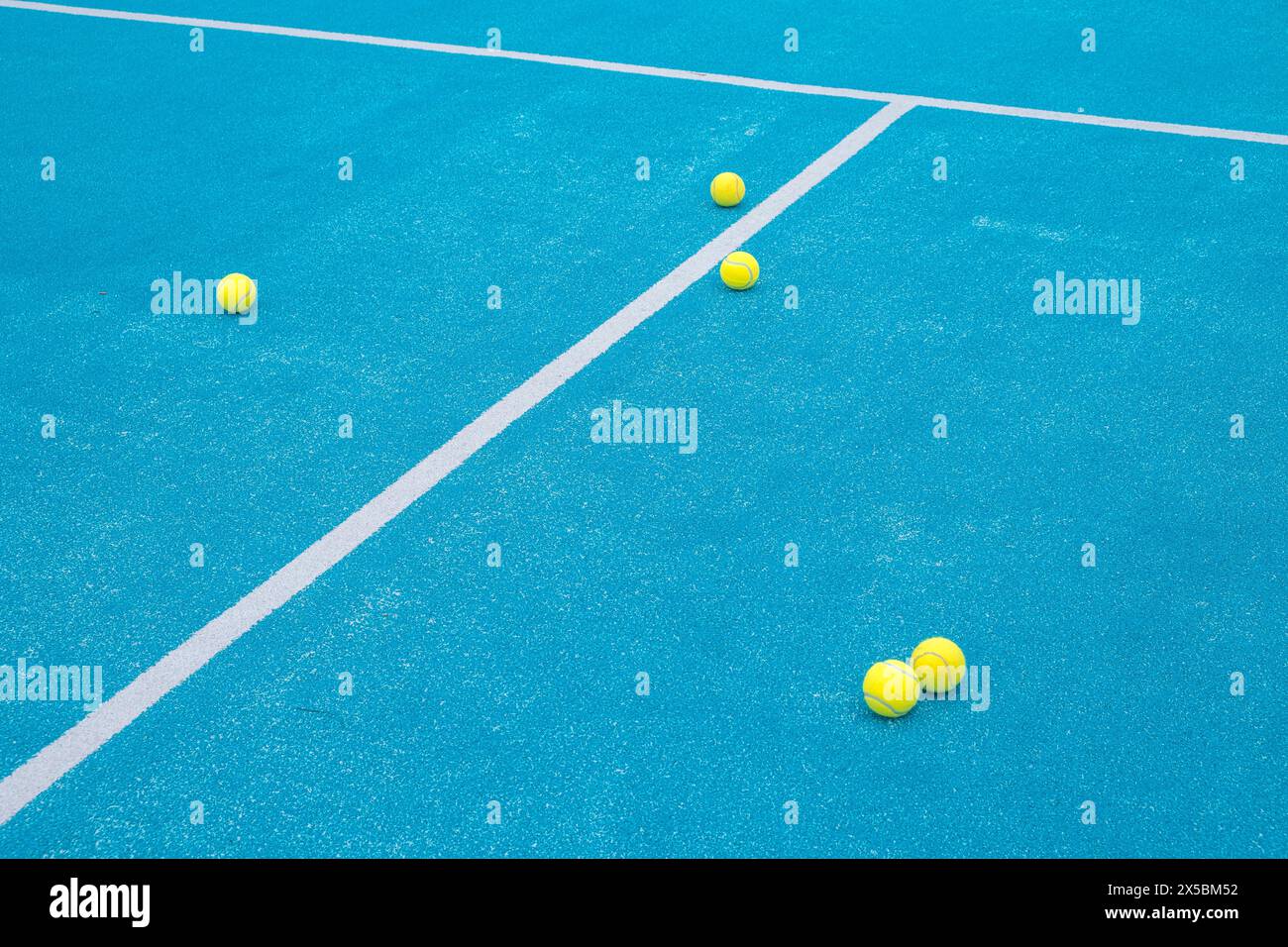 five paddle tennis balls on a blue paddle tennis court, turf ground ...