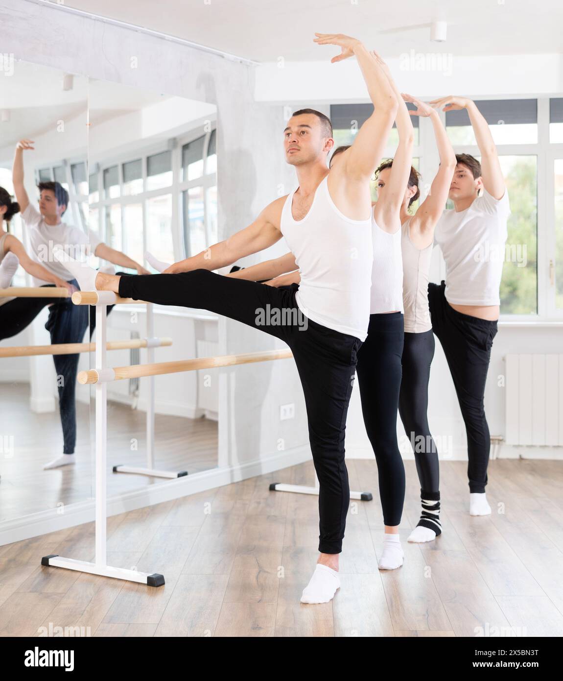 Group of dancers doing stretching at barre Stock Photo - Alamy