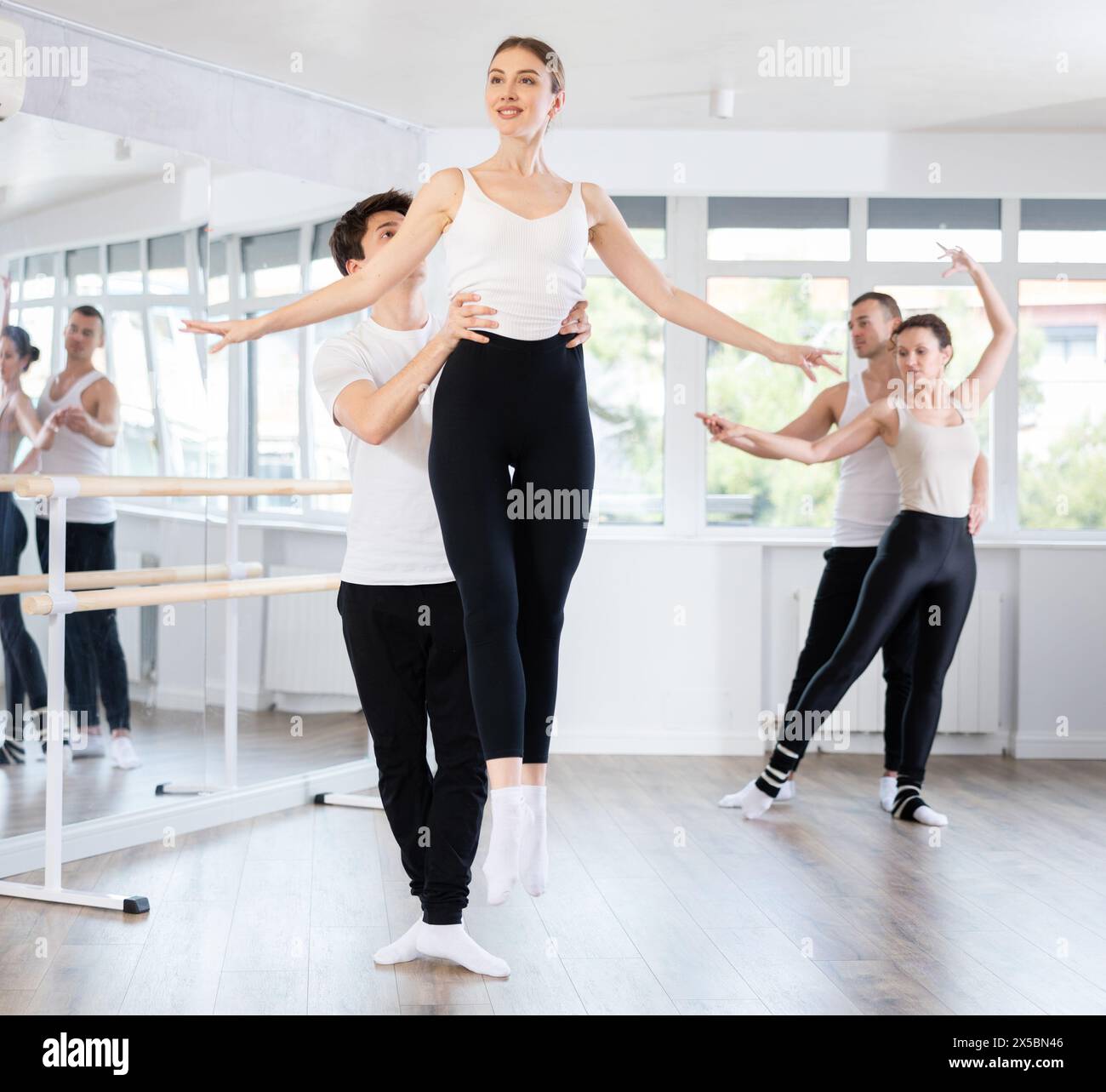 Female ballet dancer performing jump with partner support Stock Photo ...
