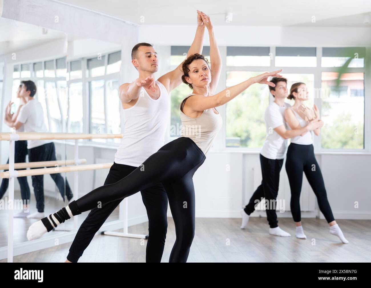 Young active man engaged in dance hall with female partner and ...